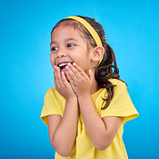 Laughing, happy and child looking curious while isolated on a blue ...