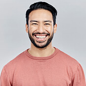 Face portrait, smile and happy Asian man in studio isolated on a gray ...