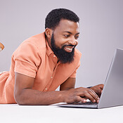 Happy black man, laptop and studio floor to search social media, online ...
