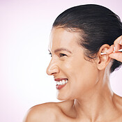 Woman, cotton and clean ear in studio with happiness for wellness ...