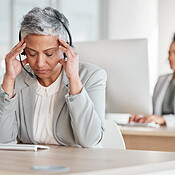 Tired call center woman with headache, fatigue and pain on computer ...