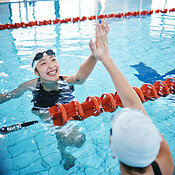 Swimming pool, sports and women high five in water for teamwork ...
