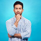 Portrait of man in shirt, blue background and thinking of ideas with ...