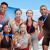 Portrait diverse group of athletes holding winners' medals and a French ...