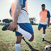 Football player, stretching legs and men training on a field for sports ...