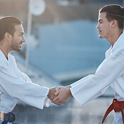 Men, karate and handshake at training fight for respect, fitness or ...