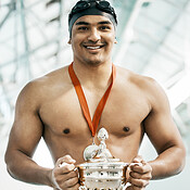 Swimmer man, trophy and portrait with smile, pride and happy for ...