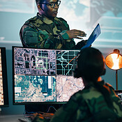 Military control room, computer and woman with team leader, headset and ...