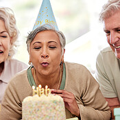 Senior woman, friends and birthday cake for blowing candles, wish and ...