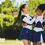 Group, hug or happy cheerleader with women outdoor in training or ...
