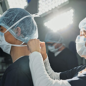 Surgery, hospital and doctors tie mask in operating room for medical ...