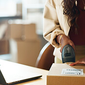 Woman, laptop and hands scan box in logistics for pricing, check or ...