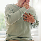 Coughing, sick and a person feeling chest for pain, heart attack or ...