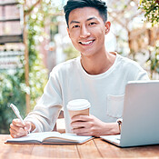 Man, writing and smile in cafe, notebook and planning for future, ideas ...