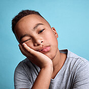 Tired child face on blue background, depression while lazy thinking and ...