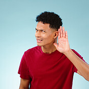 Portrait, hearing and hand gesture to ask sorry with a man listening in ...