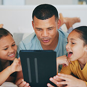 Happy, tablet and children networking with father in living room and ...