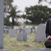 Sad woman, graveyard and rose on tombstone in mourning, loss or grief ...
