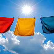 Cloth, laundry or colourful fabric hanging on a washing line for ...