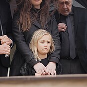 Loss, grief and people at funeral with umbrella, flowers and coffin ...