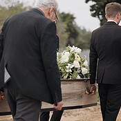 Coffin, men and pallbearers walking at graveyard ceremony outdoor at ...