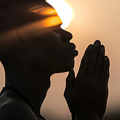 Man, relax and praying with hands together in sunset for faith ...
