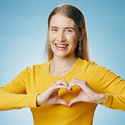 Woman, happy and heart with hands in studio, support and caring emoji ...