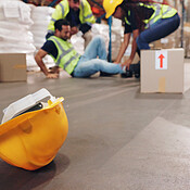 Accident, fall and hardhat with man in warehouse for delivery ...