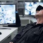 Security guard, computer screen and tired by cctv monitor for ...