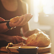 Kitchen, morning and hands of people with bread on counter with slice ...