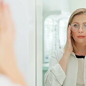 Woman, glasses and mirror at store for vision, eye care and wellness ...