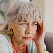 Senior woman, thinking and mental health in nursing home, hand and memory of past, retirement ...