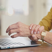 Arthritis, wrist pain and senior person with laptop after typing ...