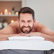 Portrait handsome caucasian man lying on a table at the spa for his ...