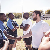 Two opponent rugby teams shaking hands before or after a match outside ...