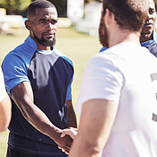 Two opponent rugby teams shaking hands before or after a match outside ...