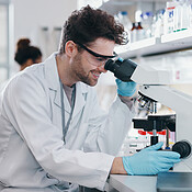 Medical, research and man with microscope, biotech and check experiment ...