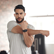 Portrait of one fit young hispanic man stretching arms and shoulders ...