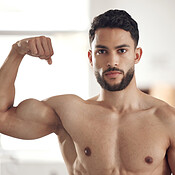 Portrait of one fit young hispanic man flexing his biceps to show big ...