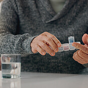 Old man, hands and pill container in home, arthritis treatment and ...