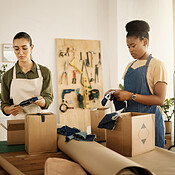 Two colleagues unpacking boxes. Fashion designers unpack stock order ...