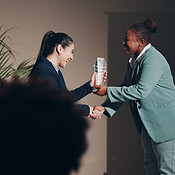 Handshake, award and smile of women, seminar and congratulations for ...