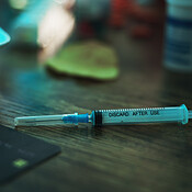 Drugs, addiction and needle on table in dark apartment with opioid ...