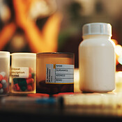 Drugs, container and pills on table in dark apartment with opioid ...