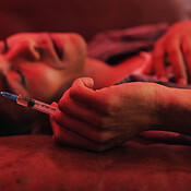 Drugs, overdose and man on couch with syringe, health risk and narcotic ...