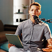 Tablet, man and radio presenter with microphone for live streaming ...