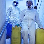 Chemical portrait, protection and people in hazmat suit on stairs in ...
