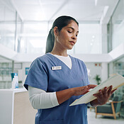 Nurse, documents and reading with woman in hospital for patient files ...