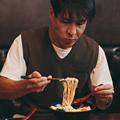 Japanese man, eating lunch and hungry in restaurant for nutrition ...