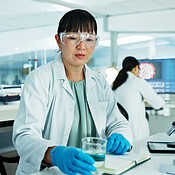Scientist, woman and beaker by computer in lab with medical research ...